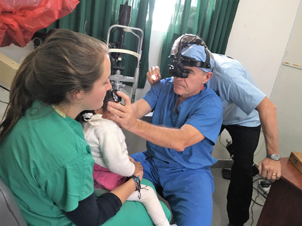 Dr. Schultz doing an Eye Exam with Rachel Brock Holding the Child Still ...